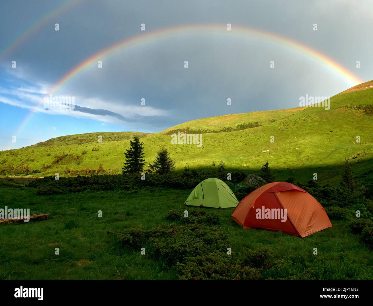 A tourist tent in the mountains on the background of a rainbow Stock ...