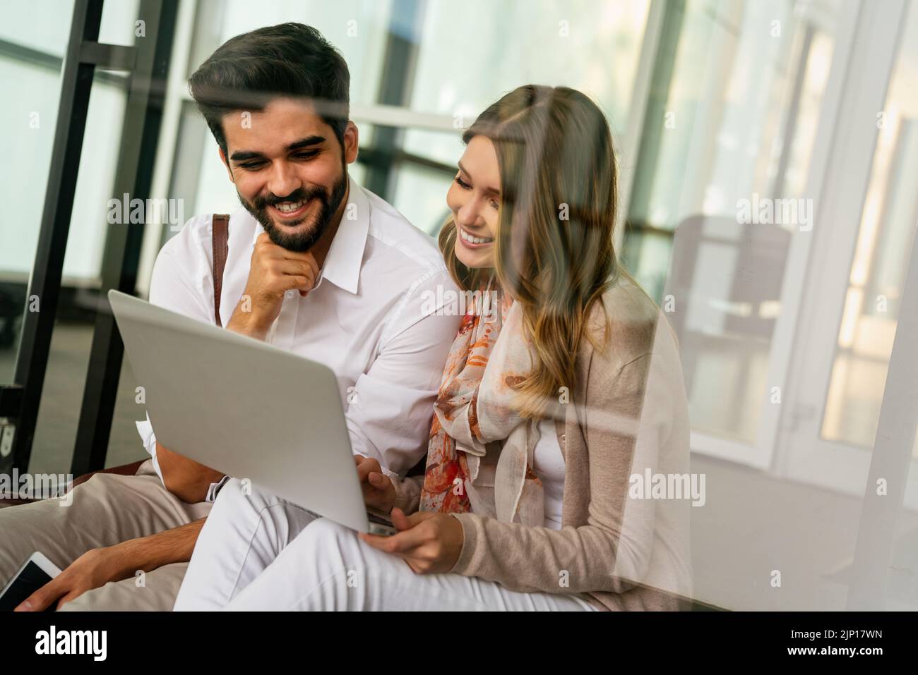 Two young successful business colleagues talking, working together ...