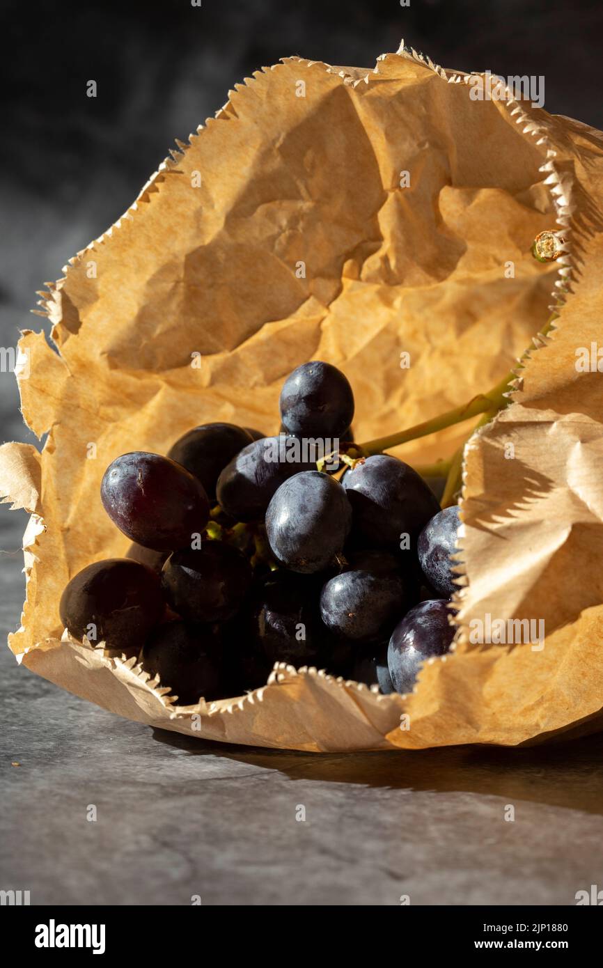 Black grapes in a brown paper bag. Eco friendly recycle packaging to ...