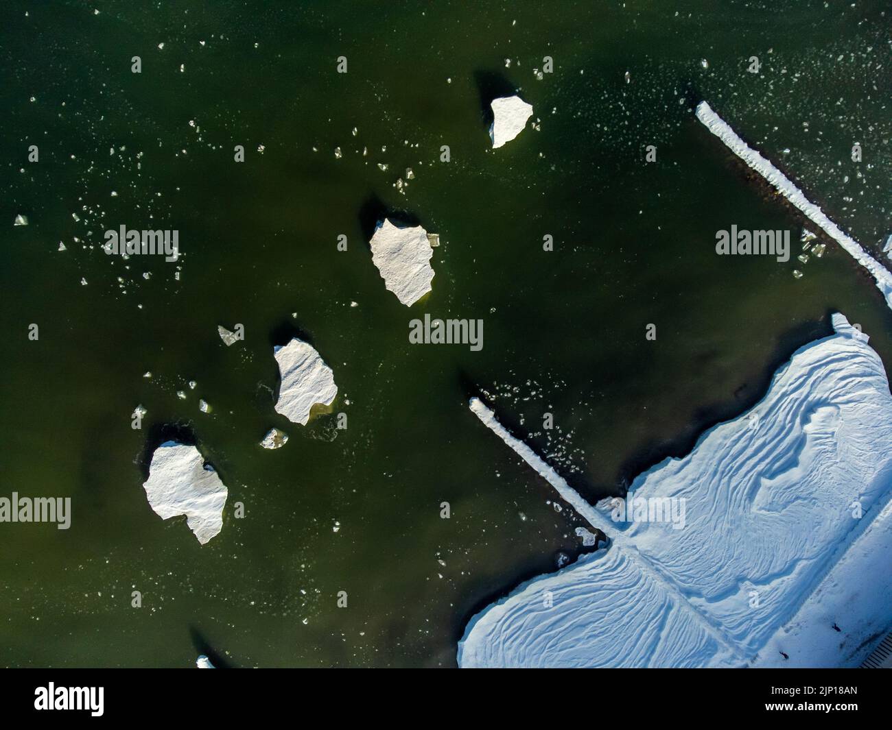 Frozen snowy seacoast with ice floating on seawater Stock Photo - Alamy