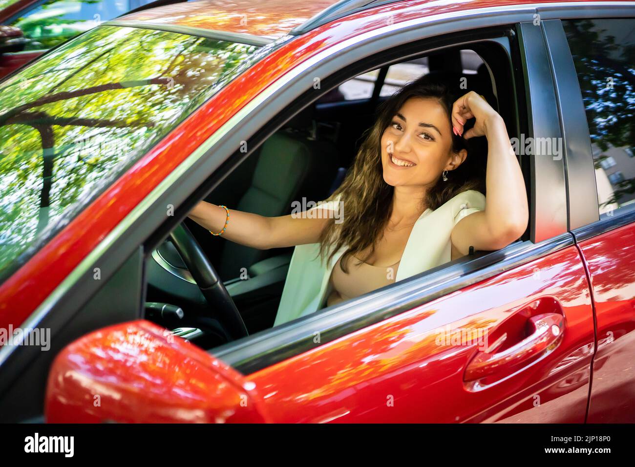 Happy Smiling Woman Driver Behind The Wheel Red Car View Through Car