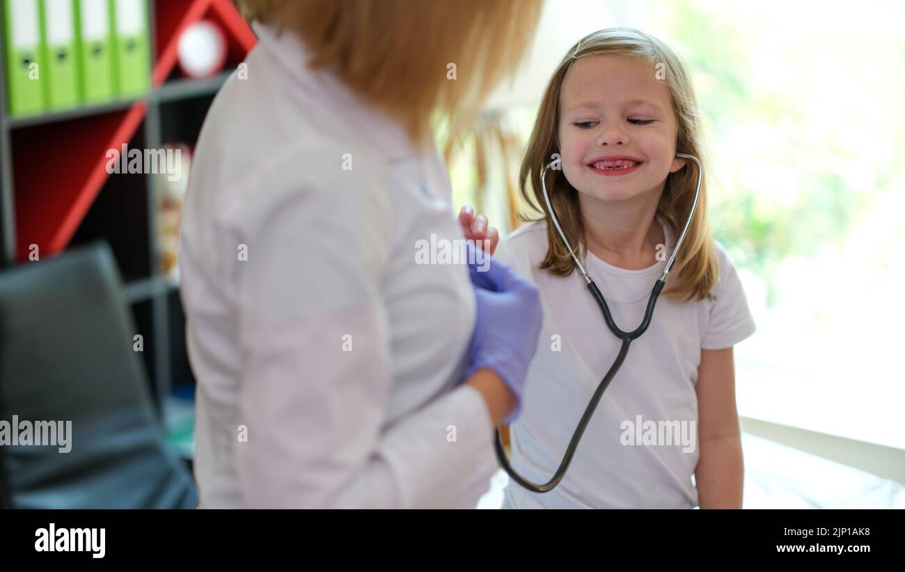 Happy smiling girl using medical stethoscope at doctor appointment ...