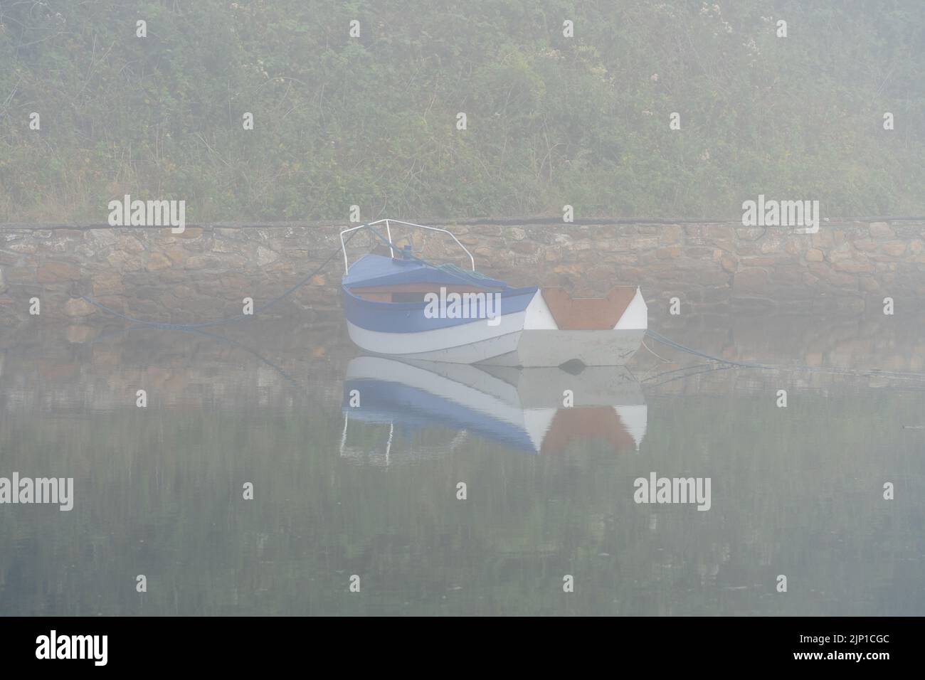 Boat in heavy sea fret at the harbour, at high tide in Seaton Sluice ...
