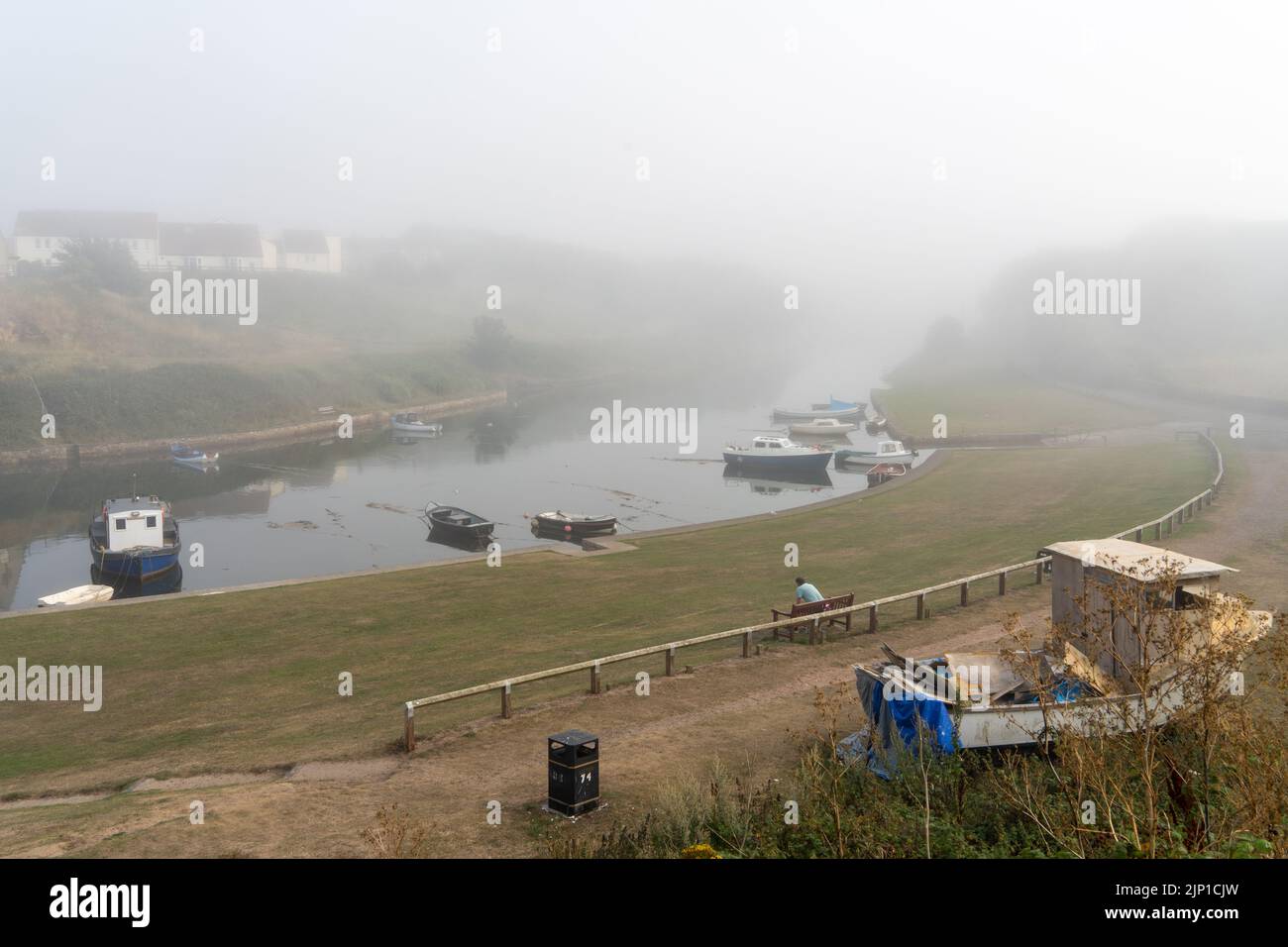 Boats in heavy sea fret at the harbour, at high tide in Seaton Sluice ...