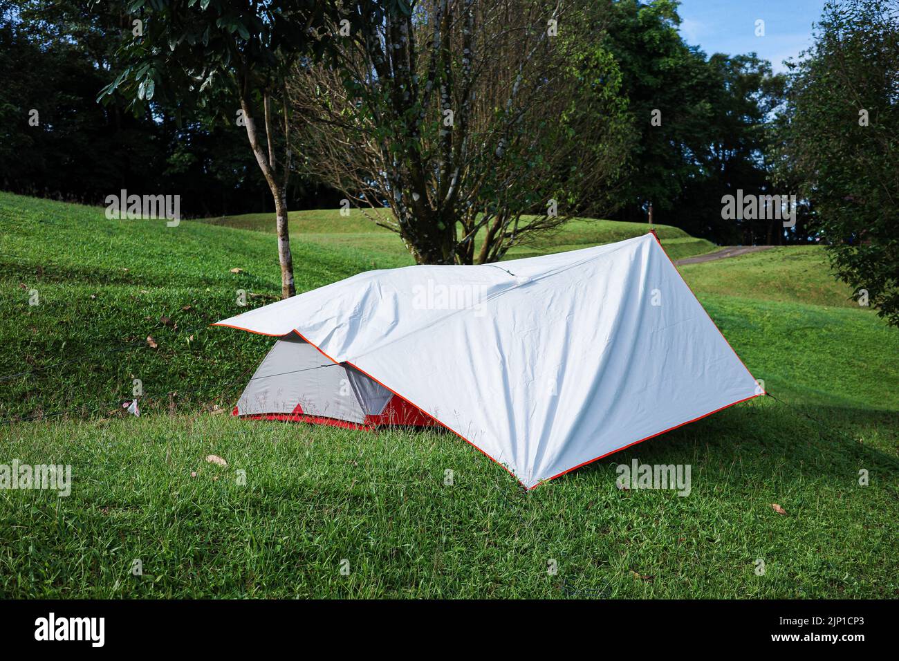 White flysheet cover tent for sunlight and rain protection on green ...