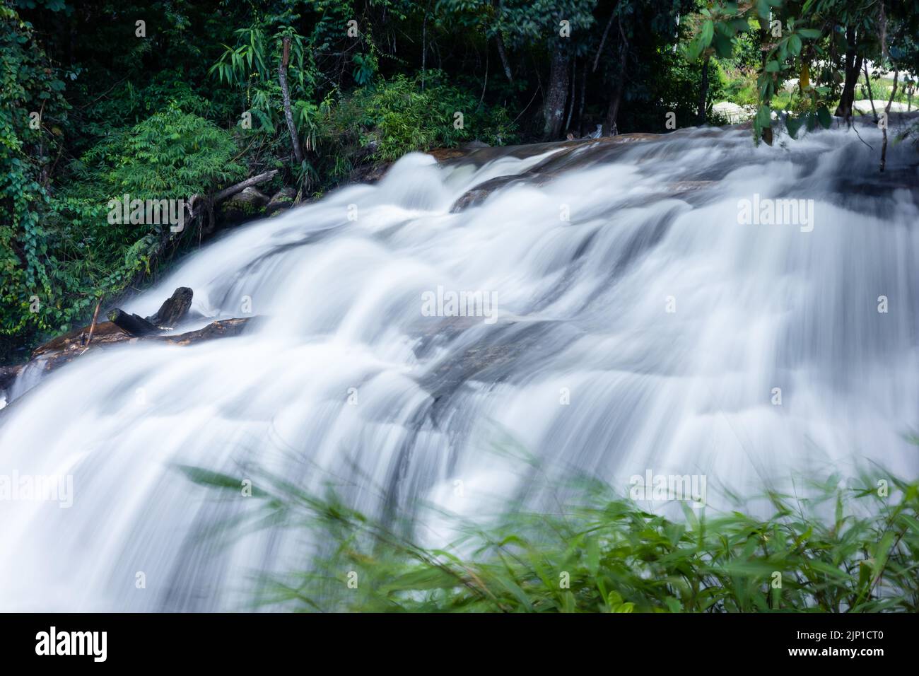 Long exposure of strong flowing water on waterfall inside tropical ...