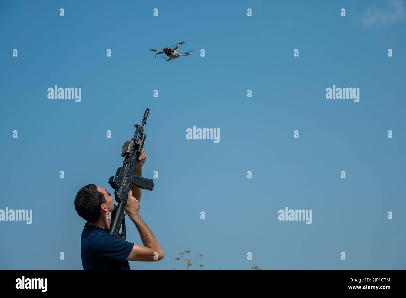 Caucasian man shoots a flying drone with a rifle Stock Photo - Alamy