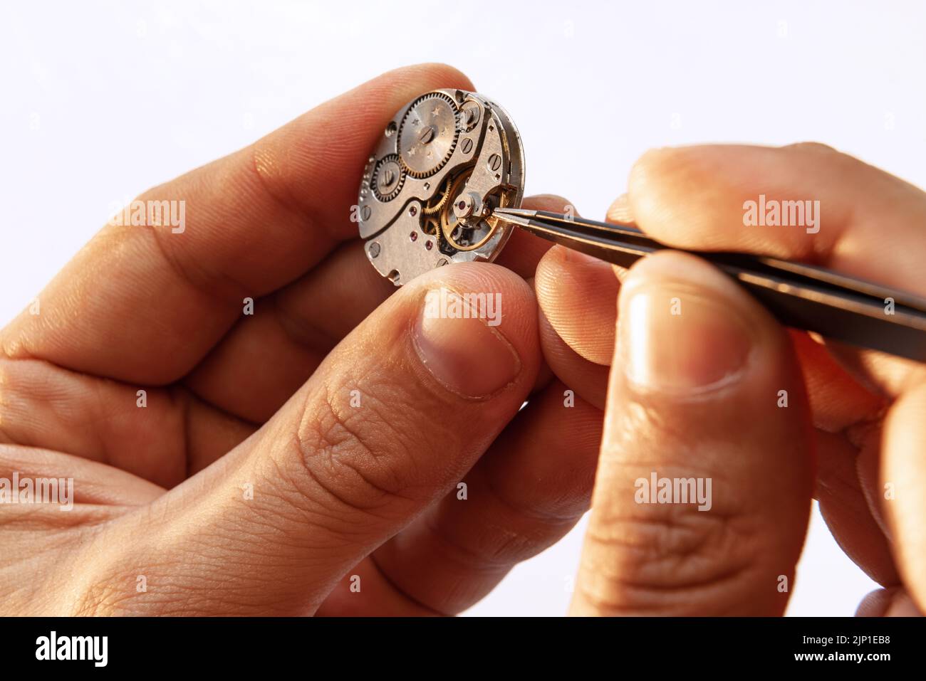 Closeup watchmaker's hands repairing mechanical watches isolated over ...
