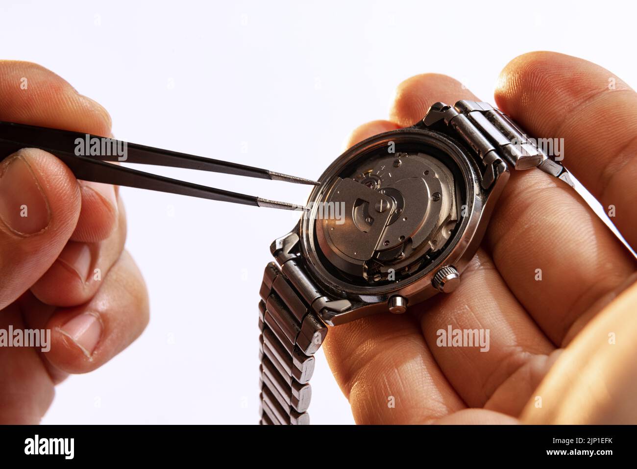 Closeup watchmaker's hands repairing mechanical watches isolated over ...