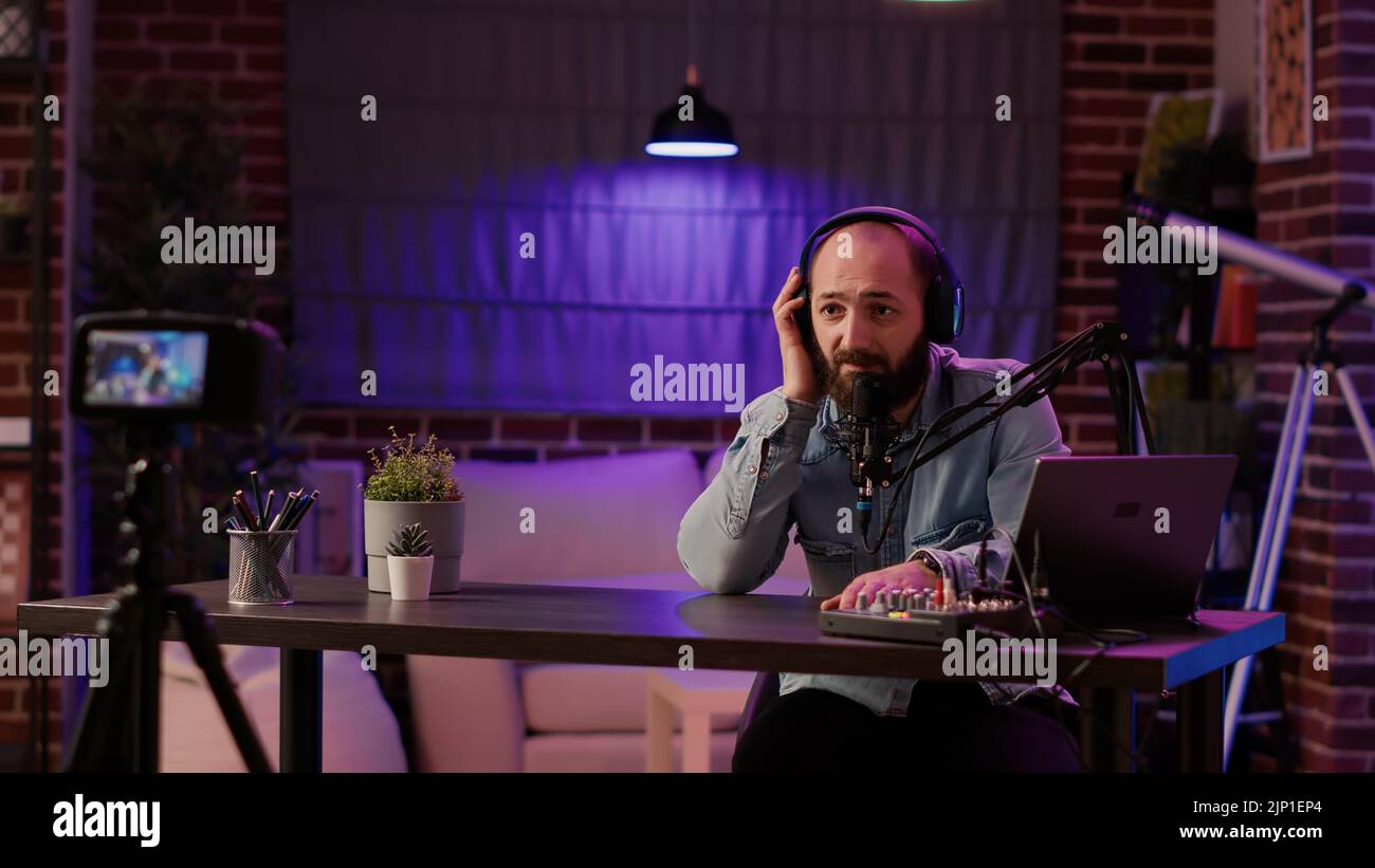 Caucasian male influencer filming video with podcast equipment in ...