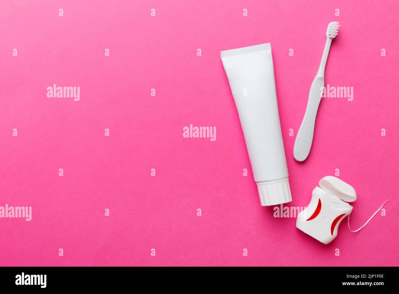 toothpaste and toothbrush top view with copy space on colored ...