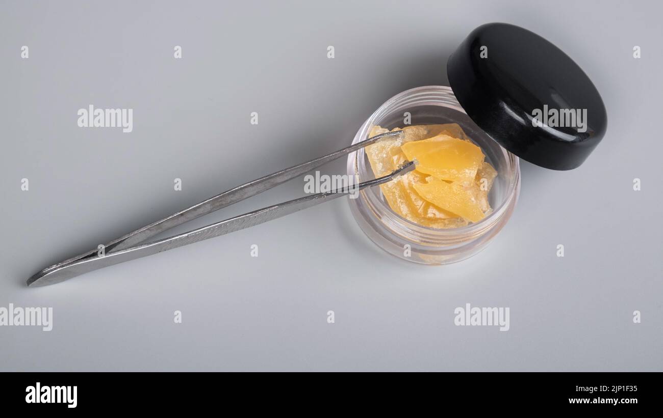 high thc cannabis concentrate,tweezers and container with piece wax ...