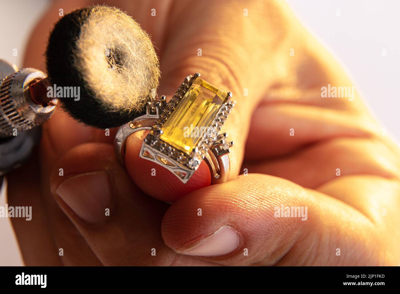 Process of polishing gemstones in jewelry. Closeup hands of jeweler at ...