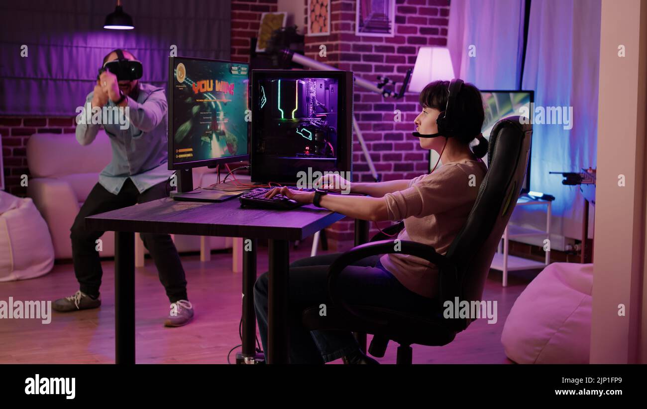 Gamer girl celebrating victory in action space simulation game while ...