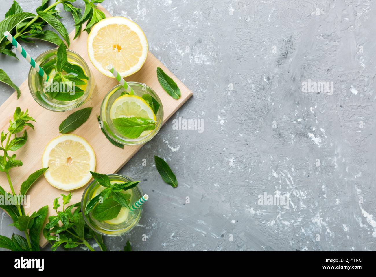 Caipirinha, Mojito cocktail, vodka or soda drink with lime, mint and straw on table background ...