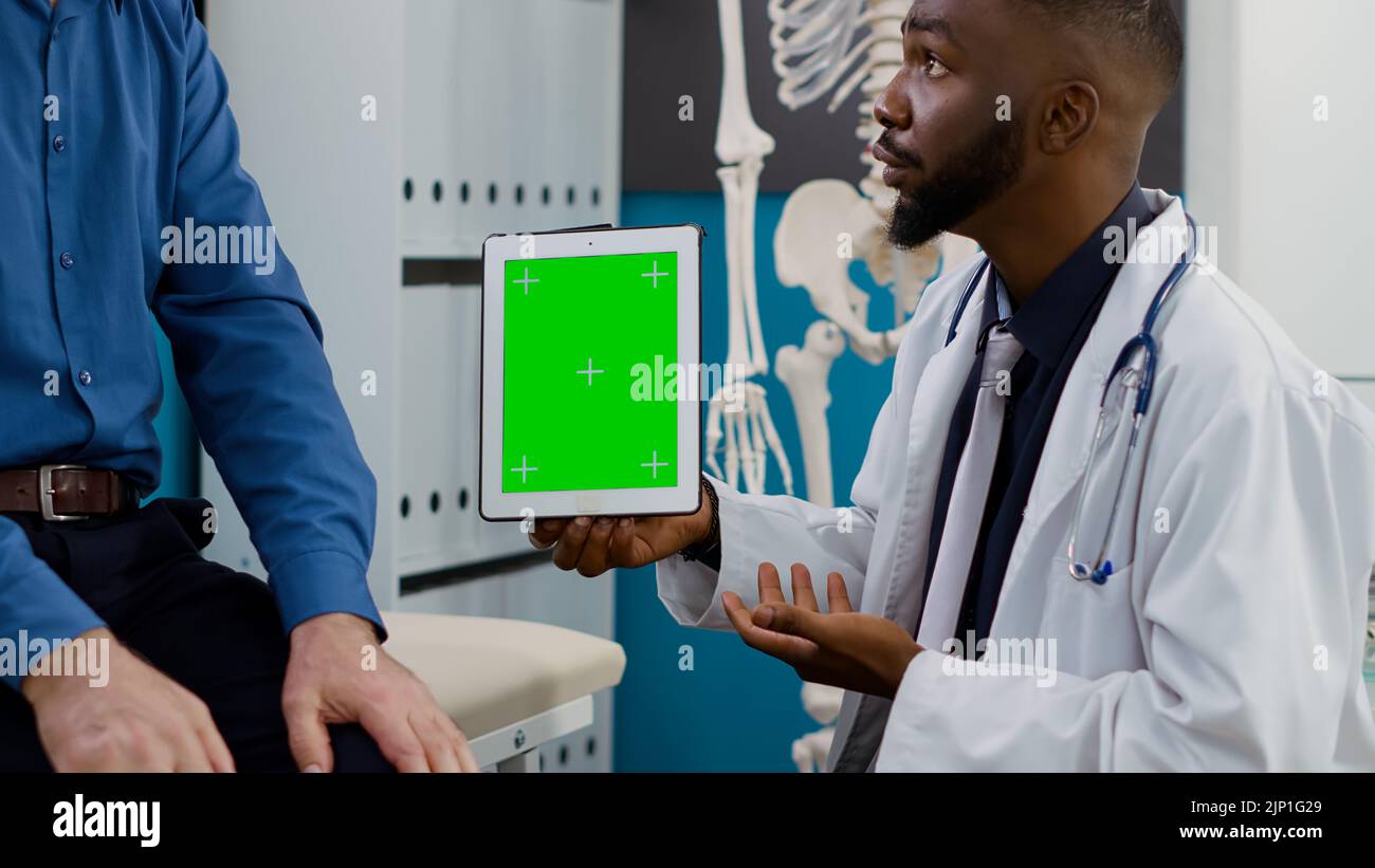 Doctor and elderly patient looking at greenscreen display on digital ...
