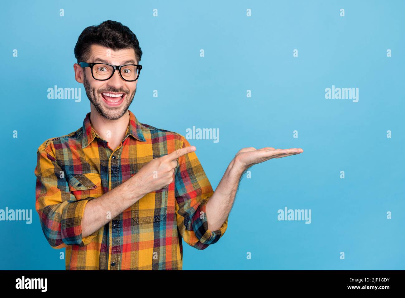 Photo of impressed bunet guy hold index empty space wear eyewear plaid ...