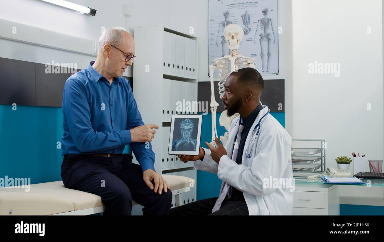 Medic physician explaining x ray scan results to patient in medical ...
