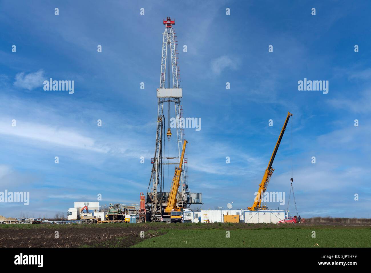 oil drilling rig and cranes on field petrochemical industry Stock Photo ...