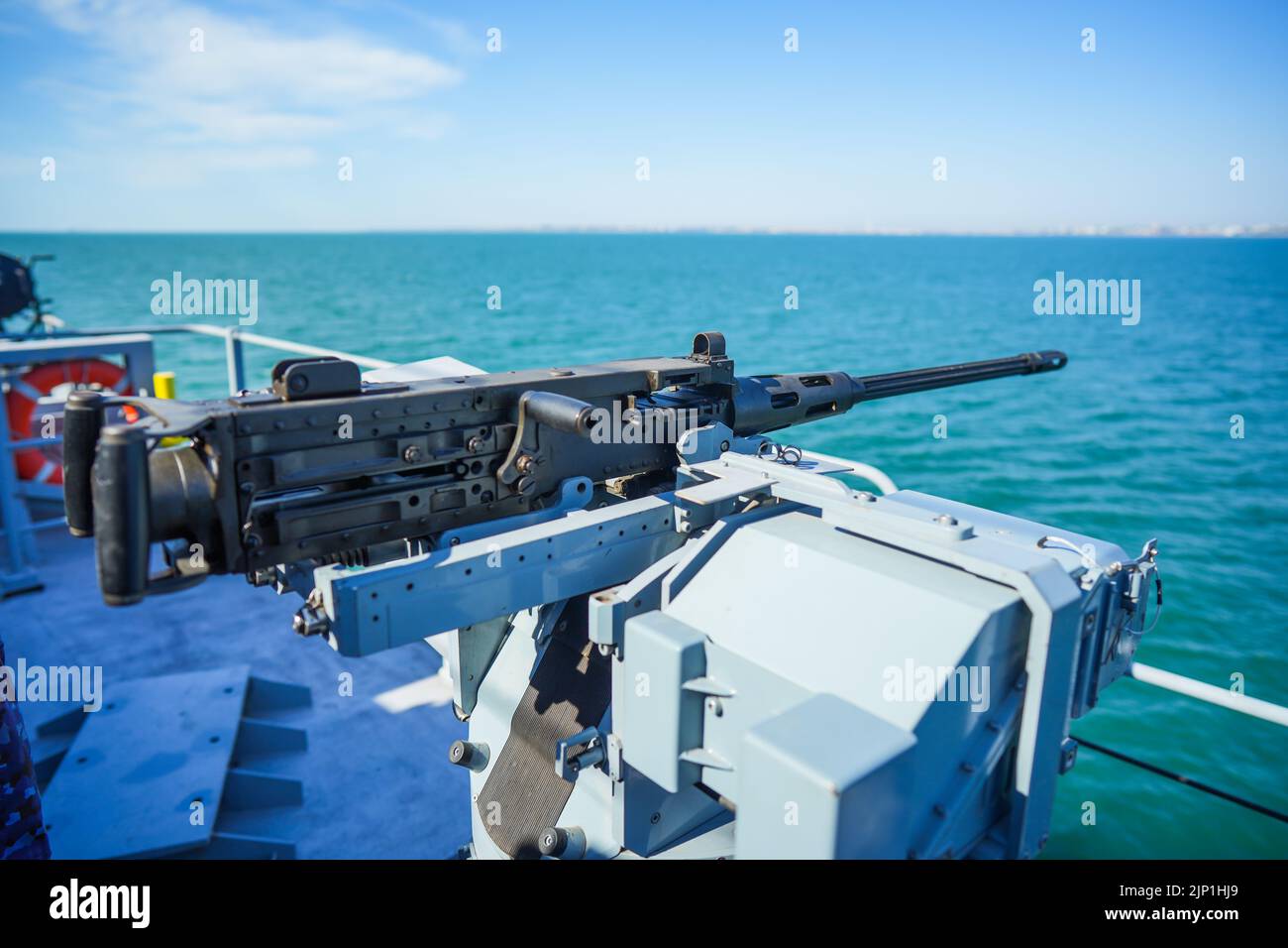 Color image of an automated machine gun on the deck of a military ship ...
