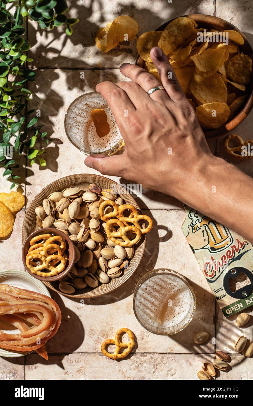 Beer outdoor party concept. Man's hand takes a glass of beer from the ...