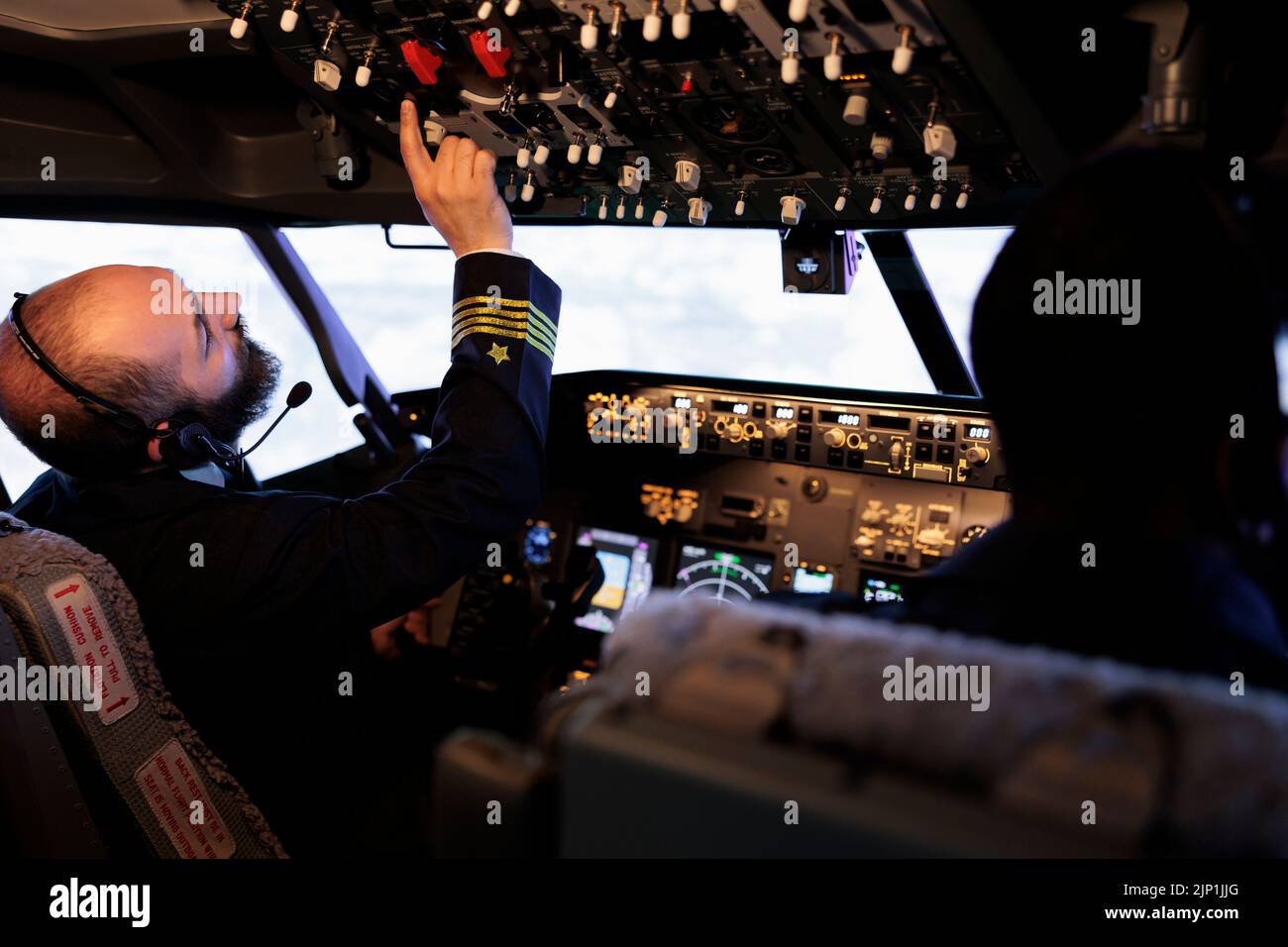 Male captain pushing buttons to start power on dashboard control, using ...