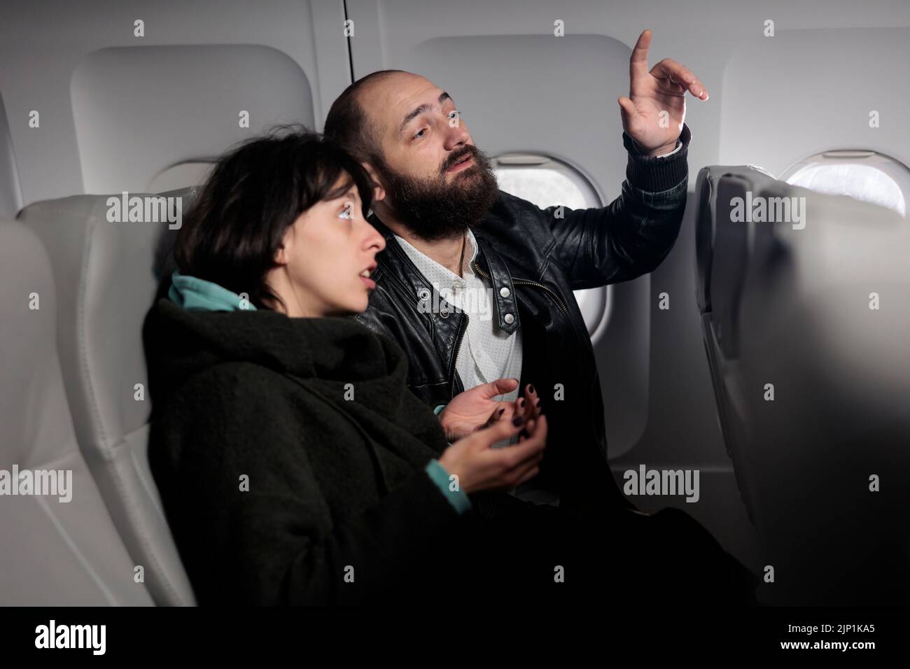 Couple of tourists waiting for flight to takeoff on airplane, being ...