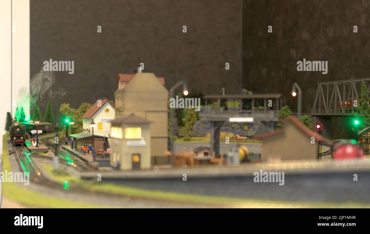 Miniature of railway station. Model of locomotive with steam moving ...