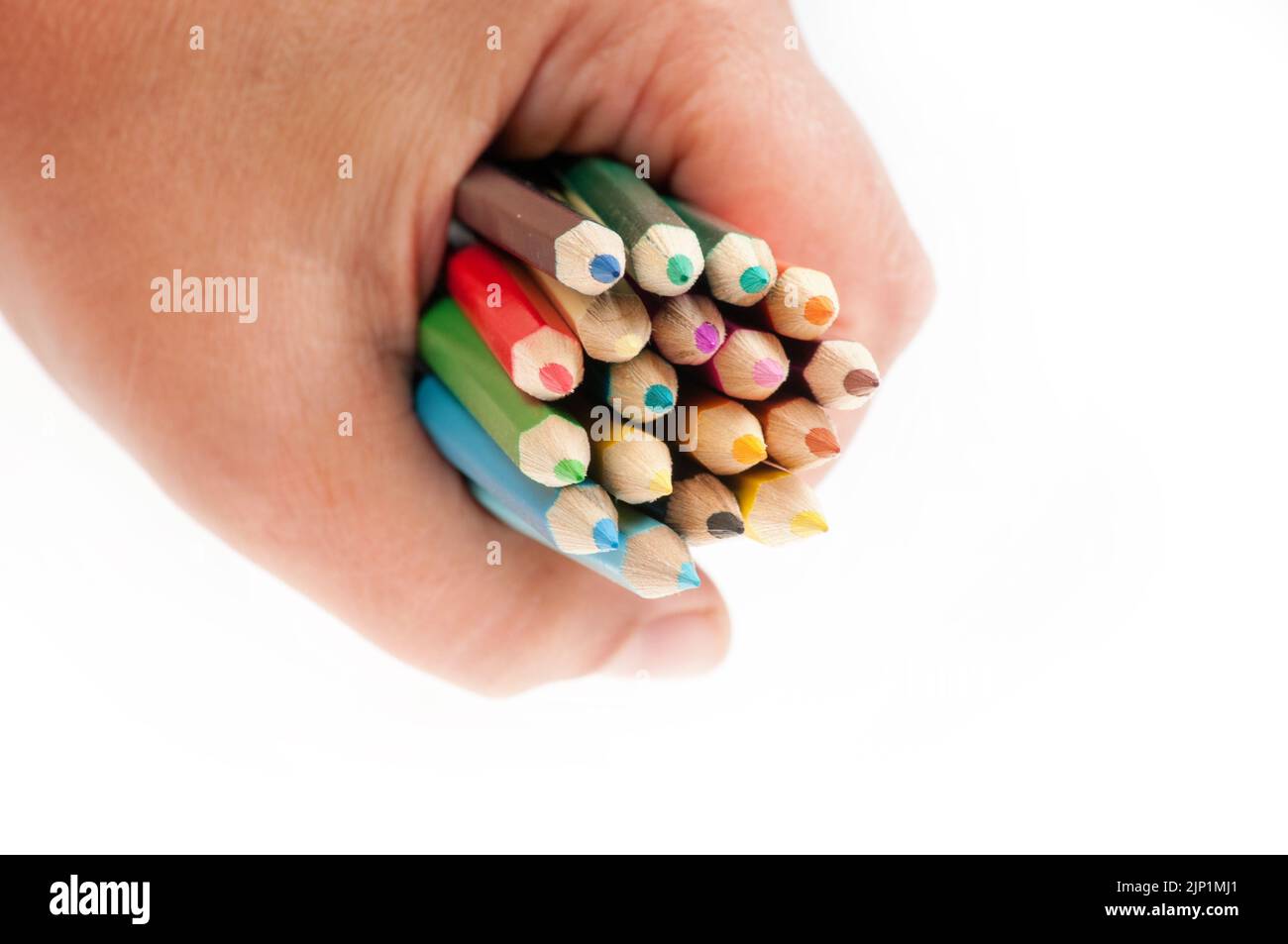 An artist holds in his hand coloured pencils with graffiti in front ...