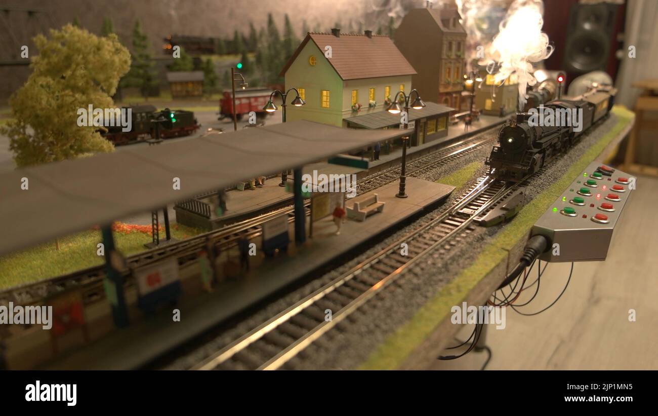 Miniature train railway station. A model of a train moves down the ...