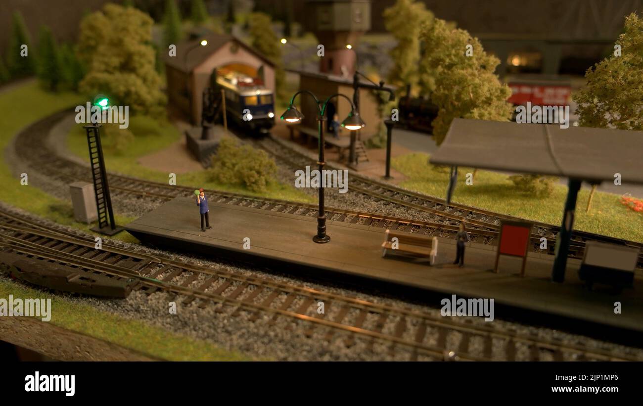 Miniature train station. Toy diesel locomotive entering at depot. Play ...