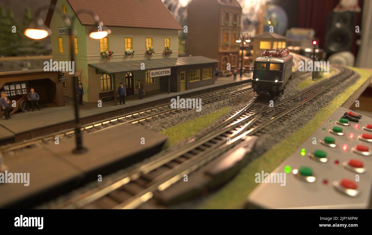 Model train with wagons is driving on model railroad. Railway station ...
