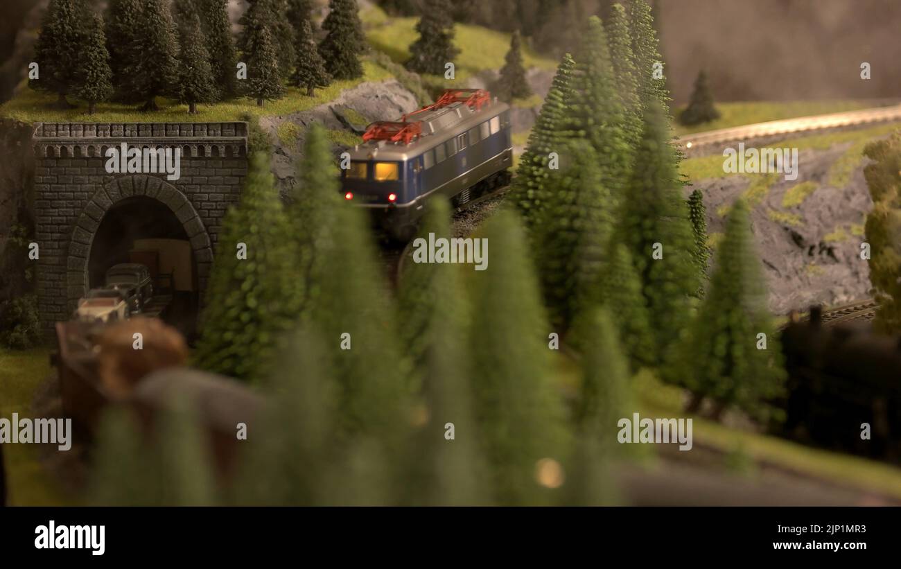 Model of steam train leaves the tunnel. Model of electric locomotive ...