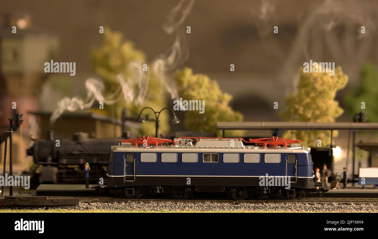 Model electric locomotive waiting for passengers at station. Miniature ...