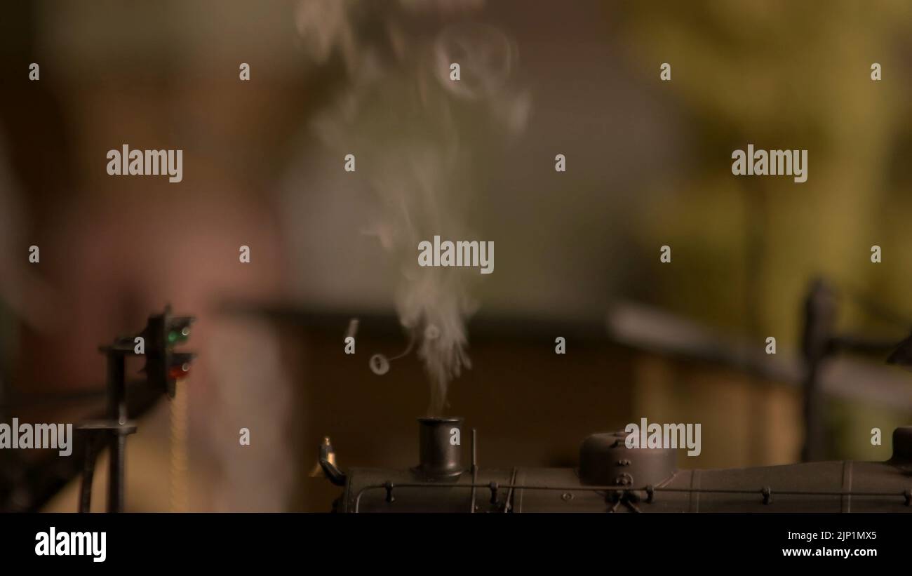 Close up smoking chimney of toy steam locomotive. Abstract blurred ...