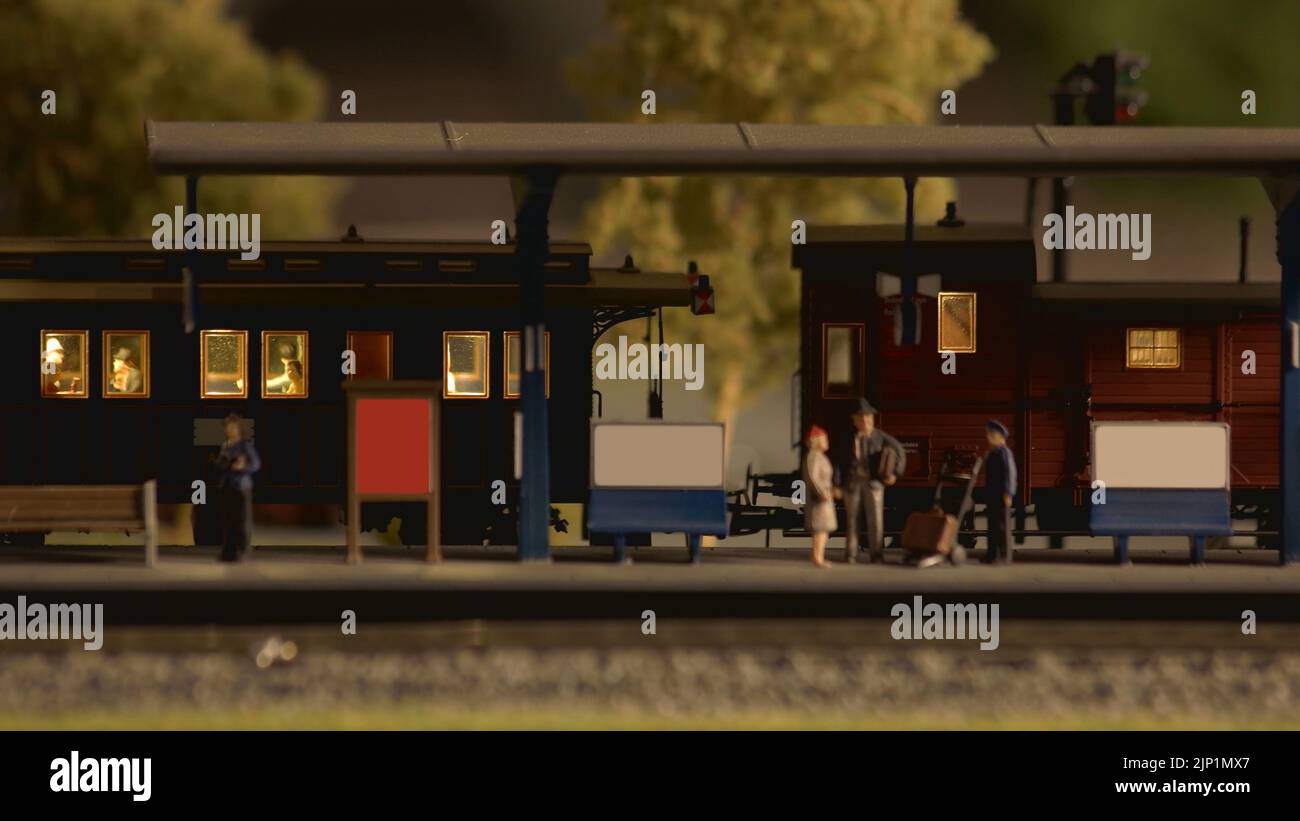 Model train at model railroad. People at miniature railway station ...