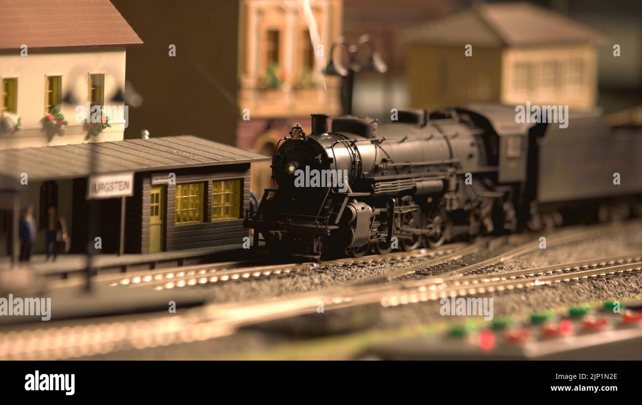 Model of railway station with moving train. Vintage old locomotive ...