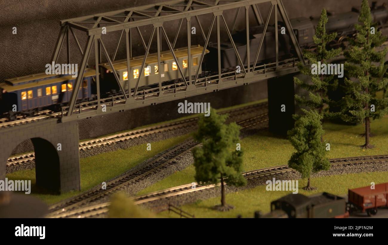 Model vintage train moving through bridge. Blue electric locomotive ...