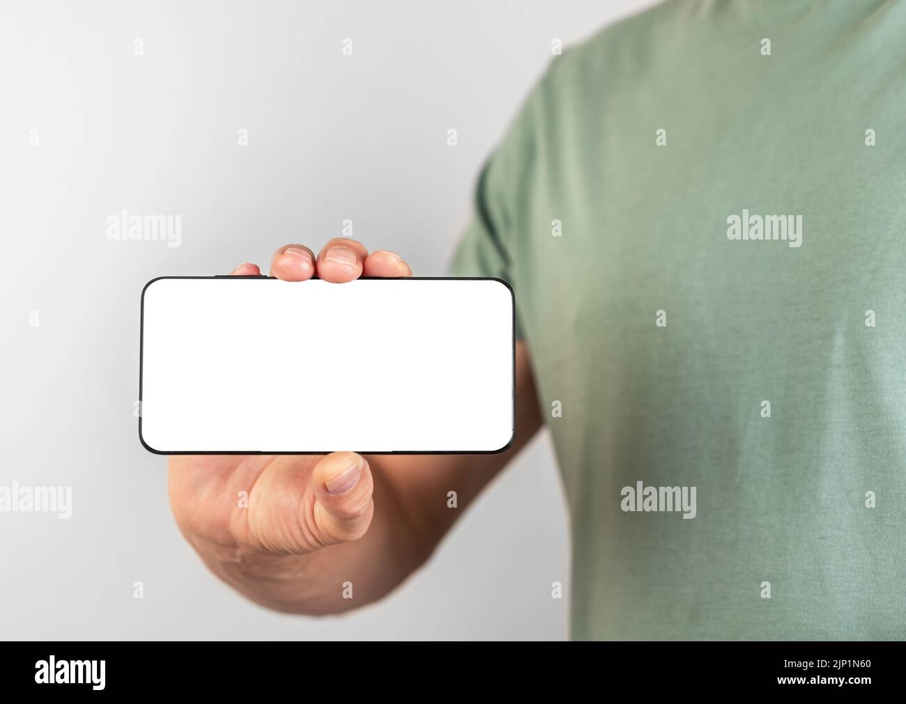 Man holding phone mockup in horizontal position. Person using ...