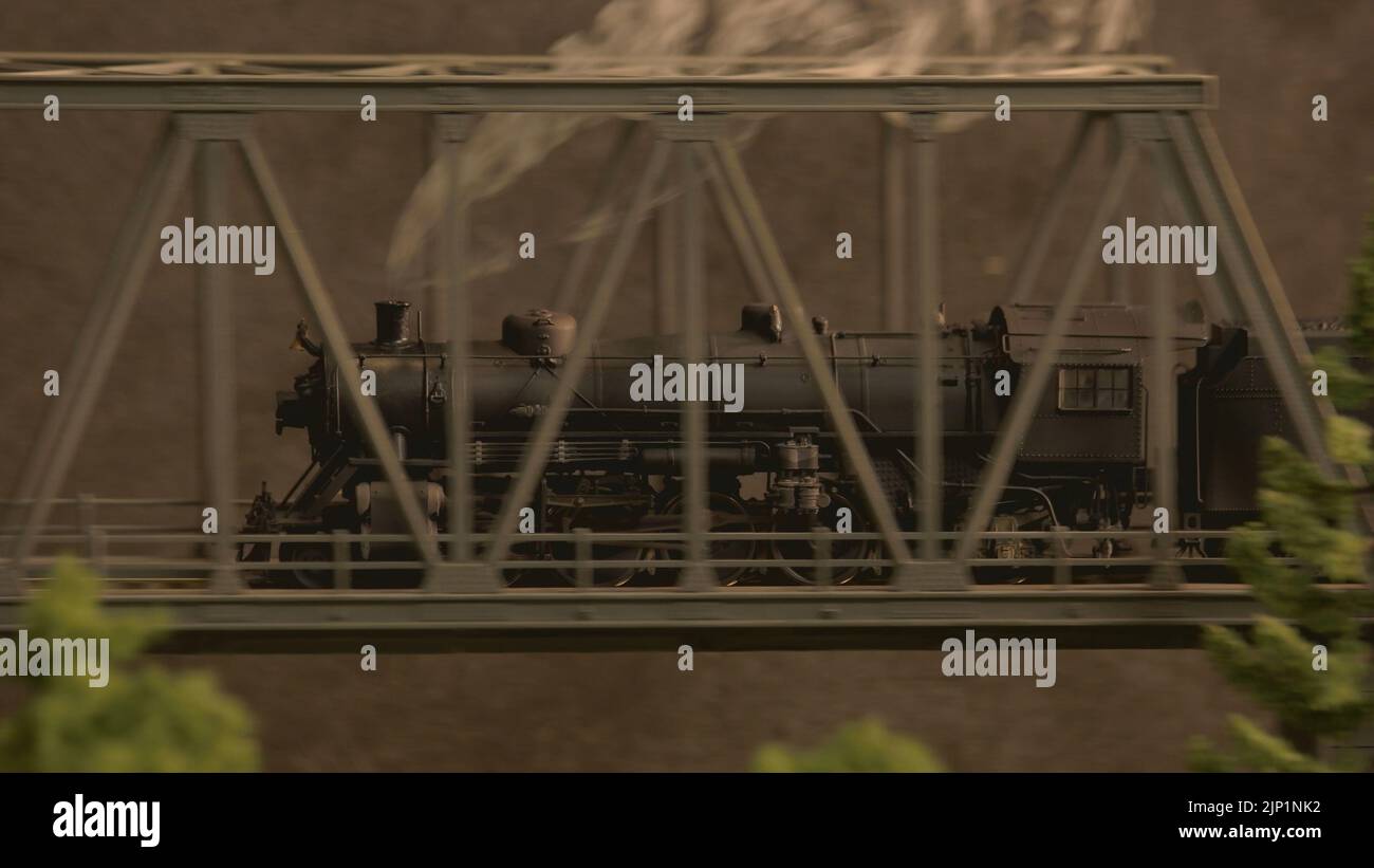 Model railroad train in motion. Toy freight locomotive with steam ...