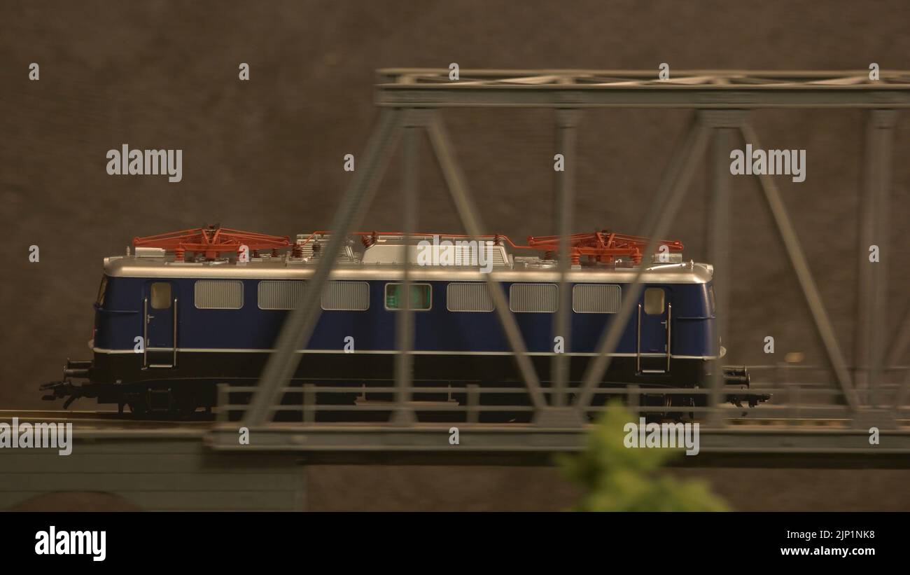 Miniature diesel train moving through the bridge. Model of vintage ...