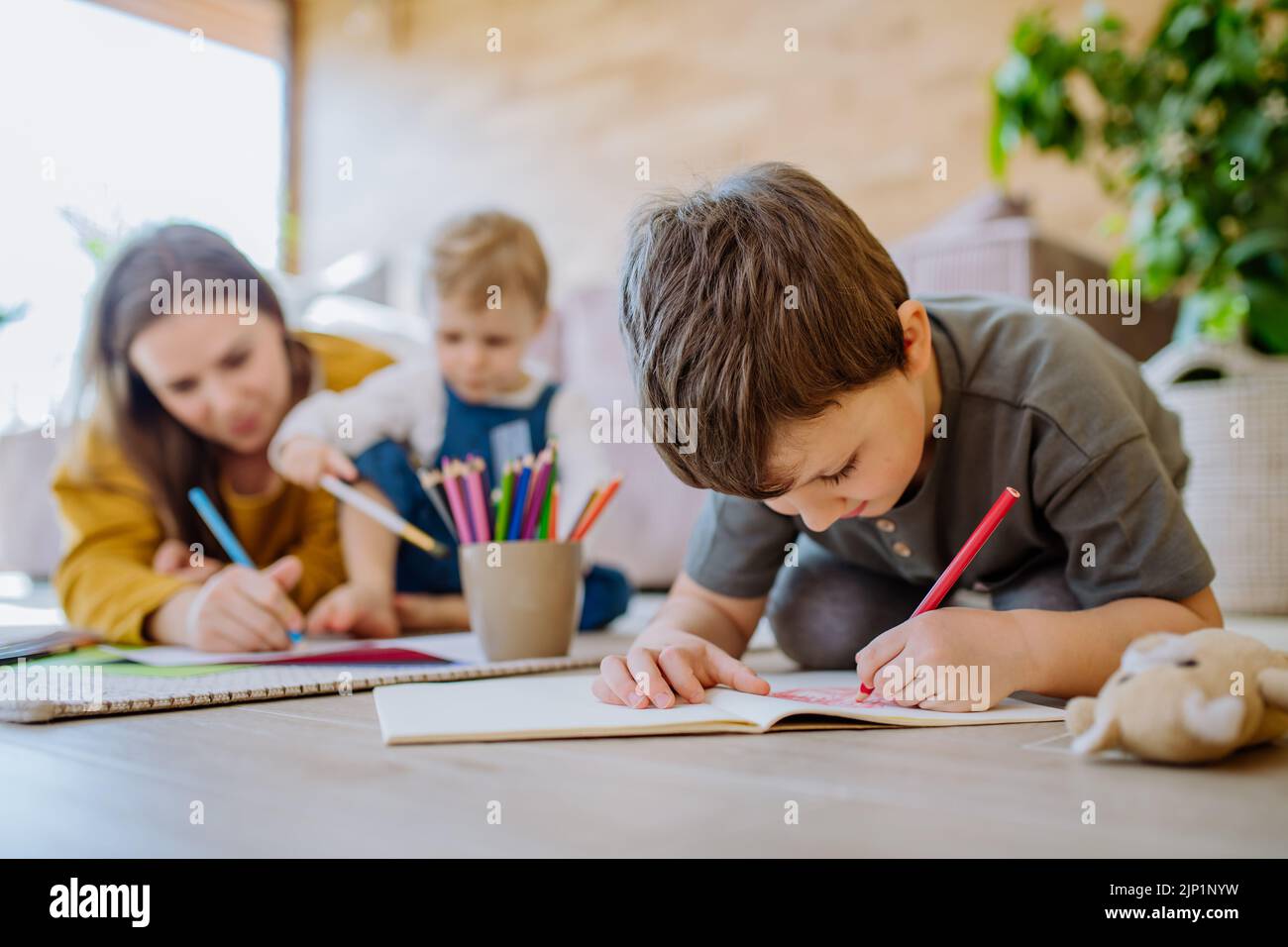 Happy mother with her little children at home drawing together Stock ...