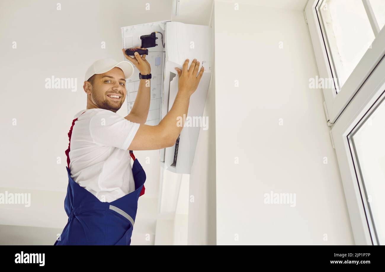 Portrait of friendly male professional worker who installs new air ...