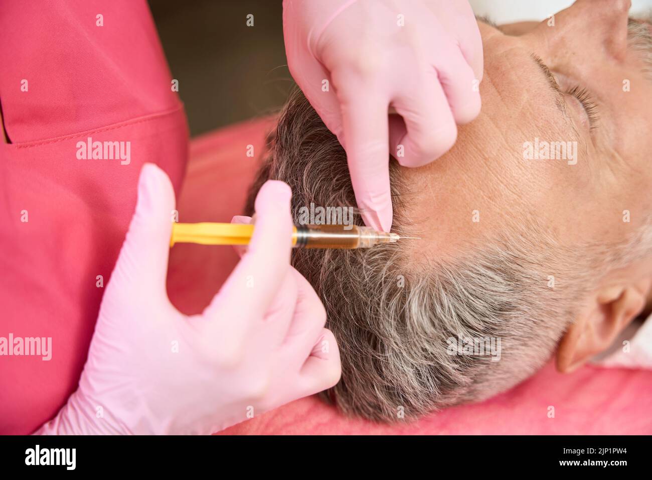 Female hands inject beauty injection into forehead near hair growth ...