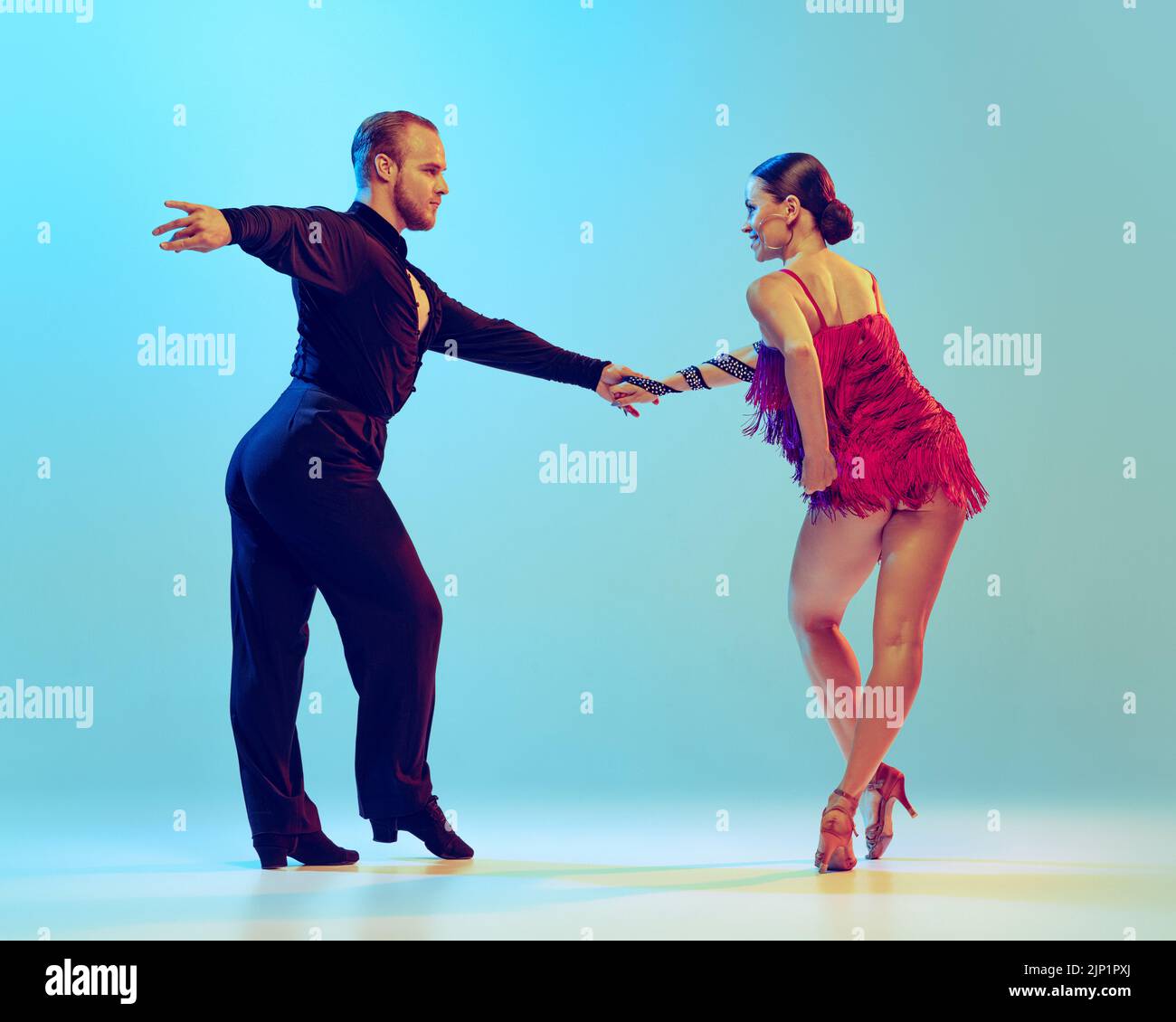 Dynamic portrait of professional dancers in stage attires dancing ...