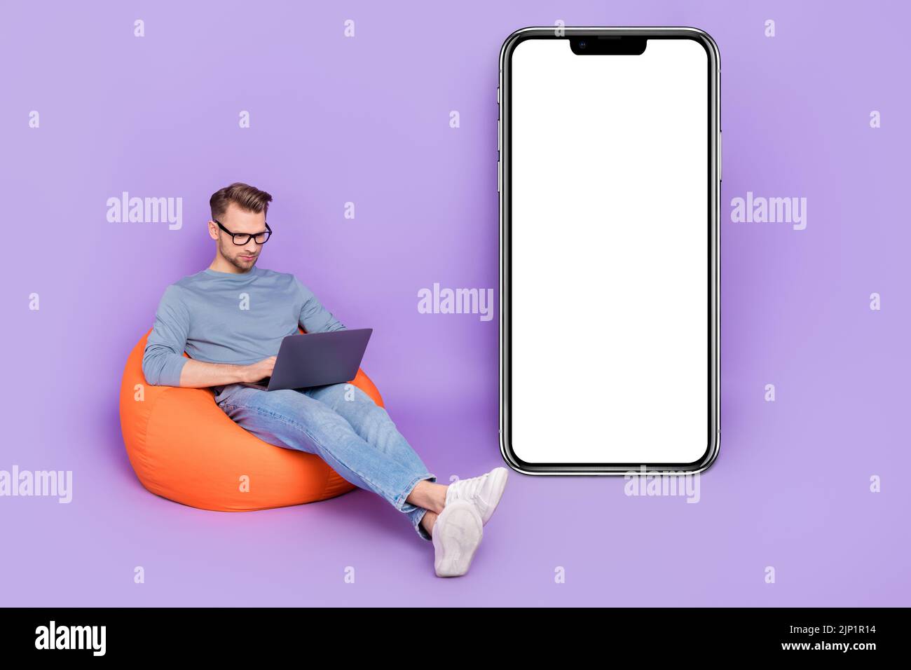 Photo of pretty busy guy dressed grey shirt sitting bean bag typing ...