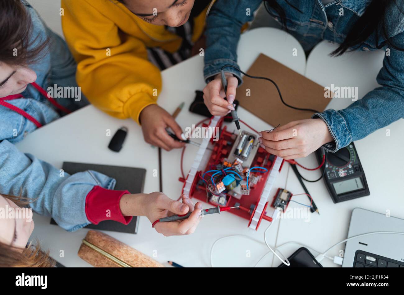 Group of high school students building and programming electric toys ...