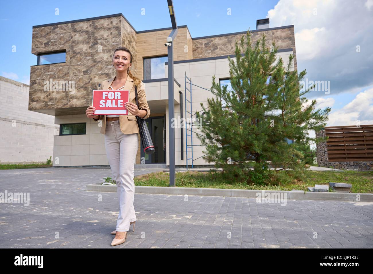 Realtor stands with sign in his hands for sale Stock Photo - Alamy