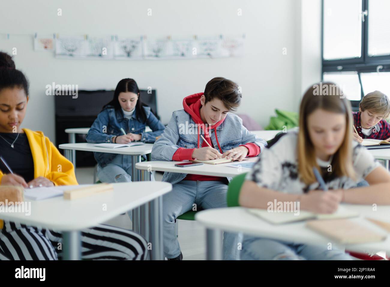 High school students paying attention in class, sitting in their desks ...