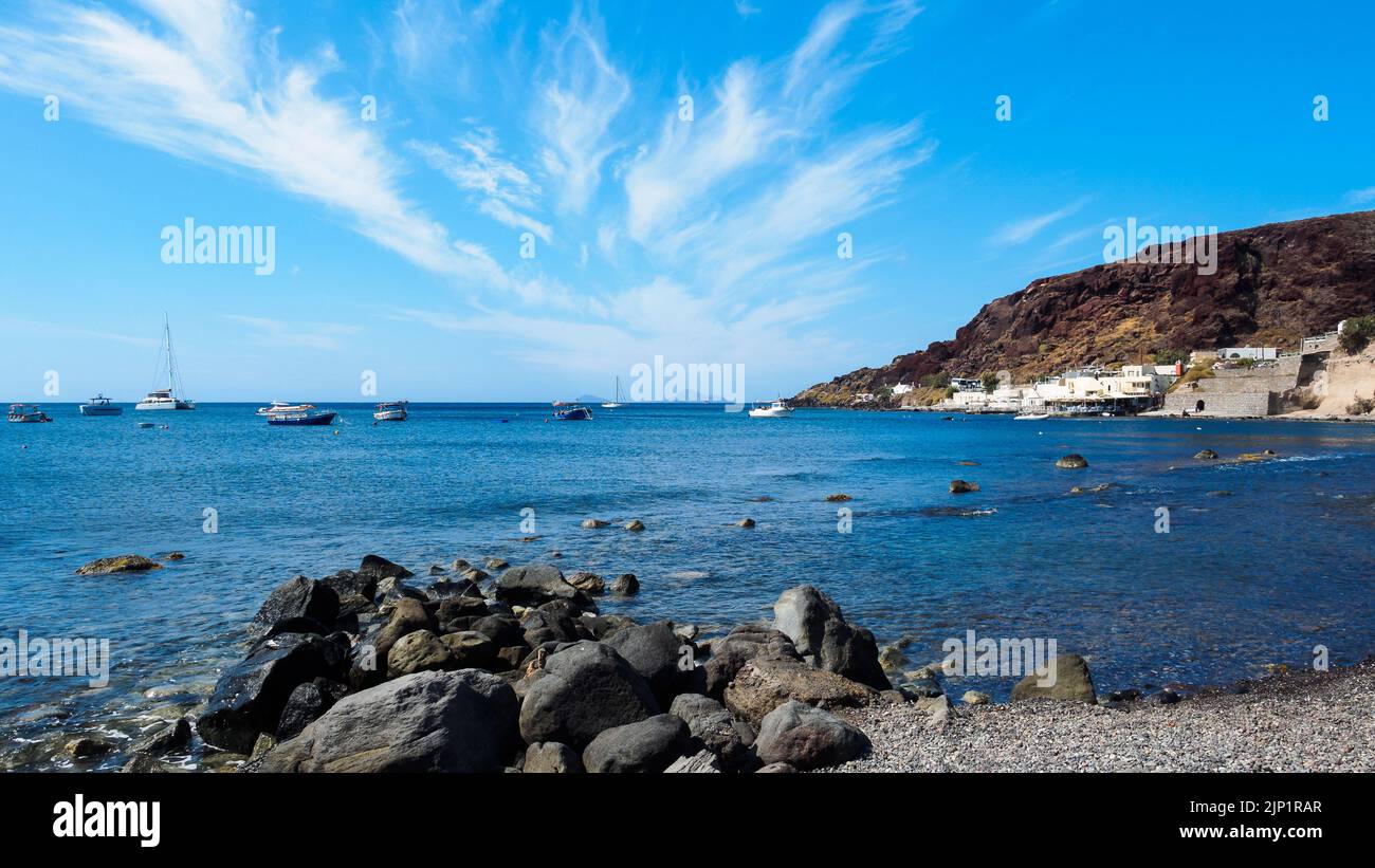 Calm sea bay with anchored boats, yachts and rocky shores Stock Photo ...